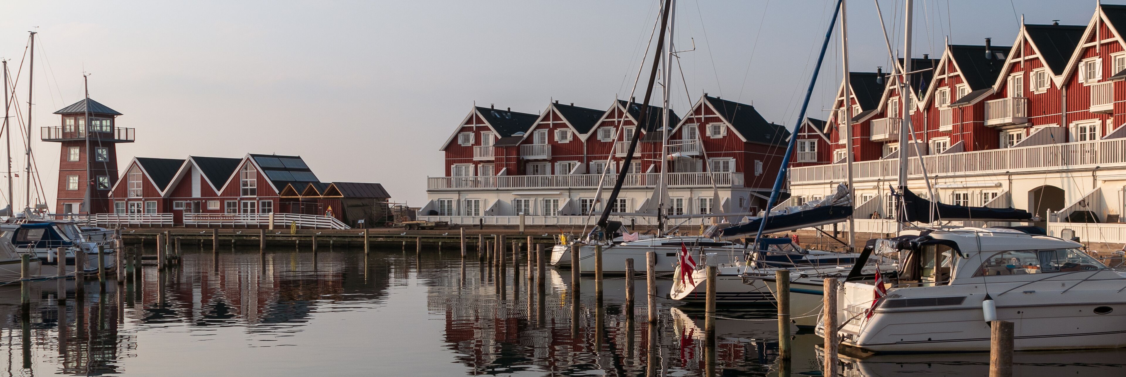 Uma marina com edifícios vermelhos e barcos atracados.