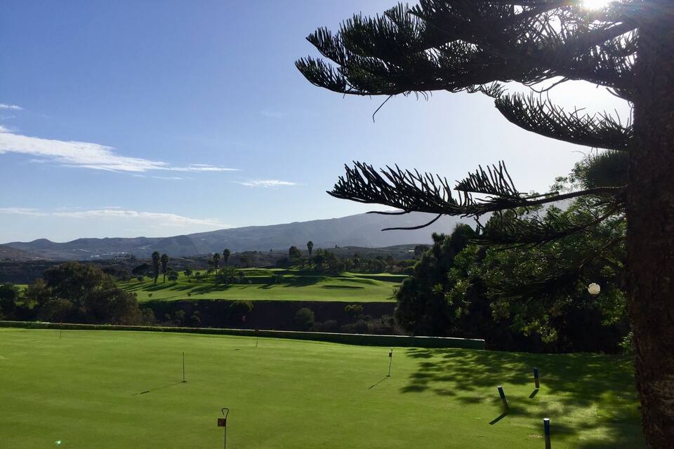 Um campo de golfe com uma montanha ao fundo.