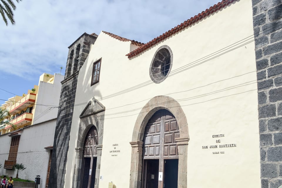 Um edifício histórico com janelas em arco e fachada de pedra.
