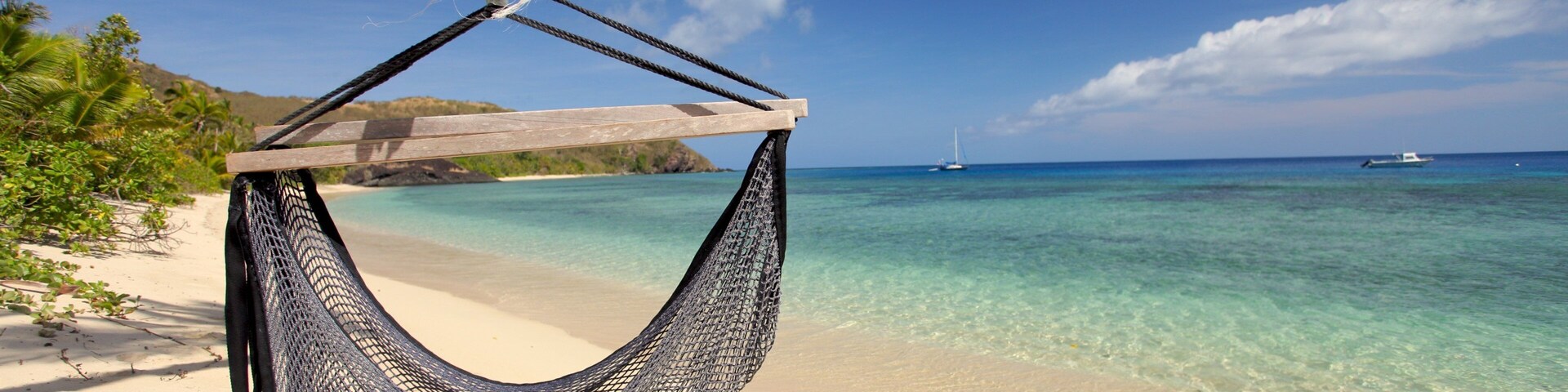 Explore the serene beauty of Naviti Island with its stunning beach and a hammock inviting relaxation by the turquoise waters