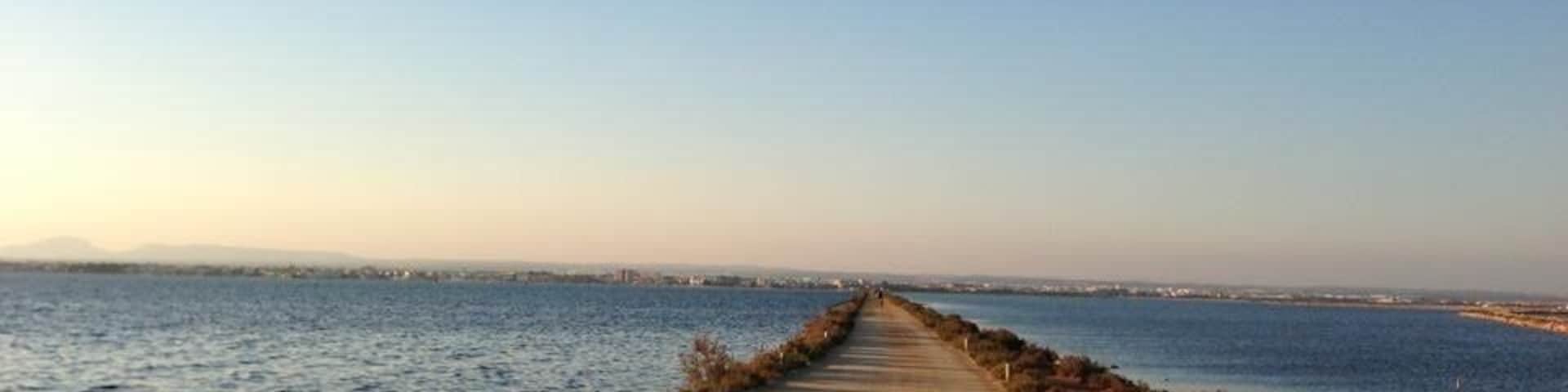 When you visit San Pedro del Pinatar, make sure to take a wall up the pier near the old wind mill. At the end there's another one. You could go further but you'd walk into the sea. This pier is one of the arms that almost close the Mar Menor. You should time it so that you walk back when the sun starts to set. Seeing the sun set behind the houses, the mountains and into the sea is wonderful.