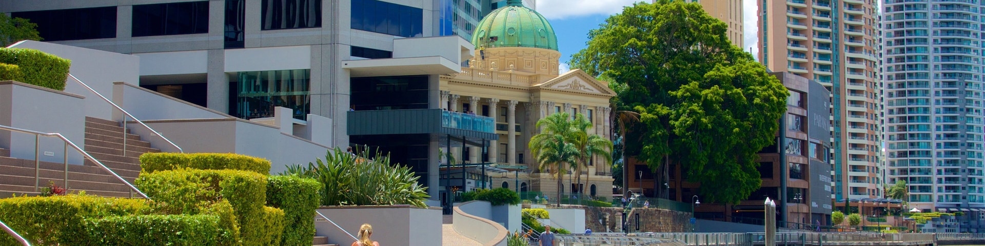 Eagle Street Pier featuring a city and a high rise building as well as an individual femail