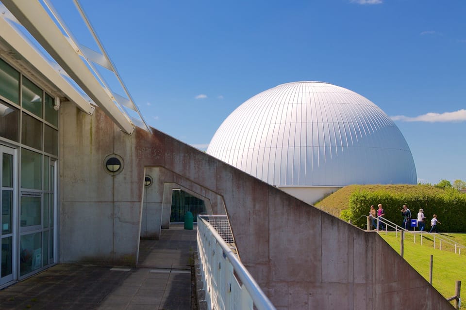 Um edifício moderno com grandes janelas e estrutura em cúpula.