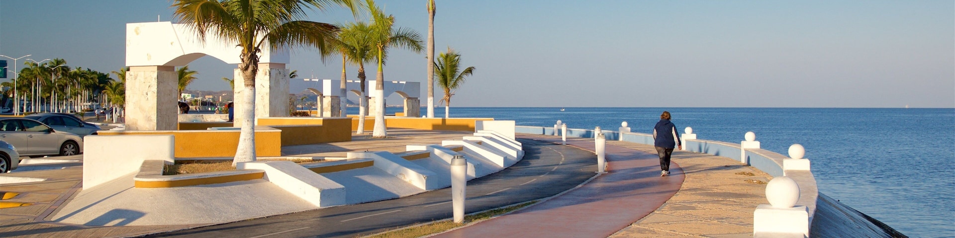 Campeche Waterfront Promenade which includes general coastal views and a sunset as well as an individual femail
