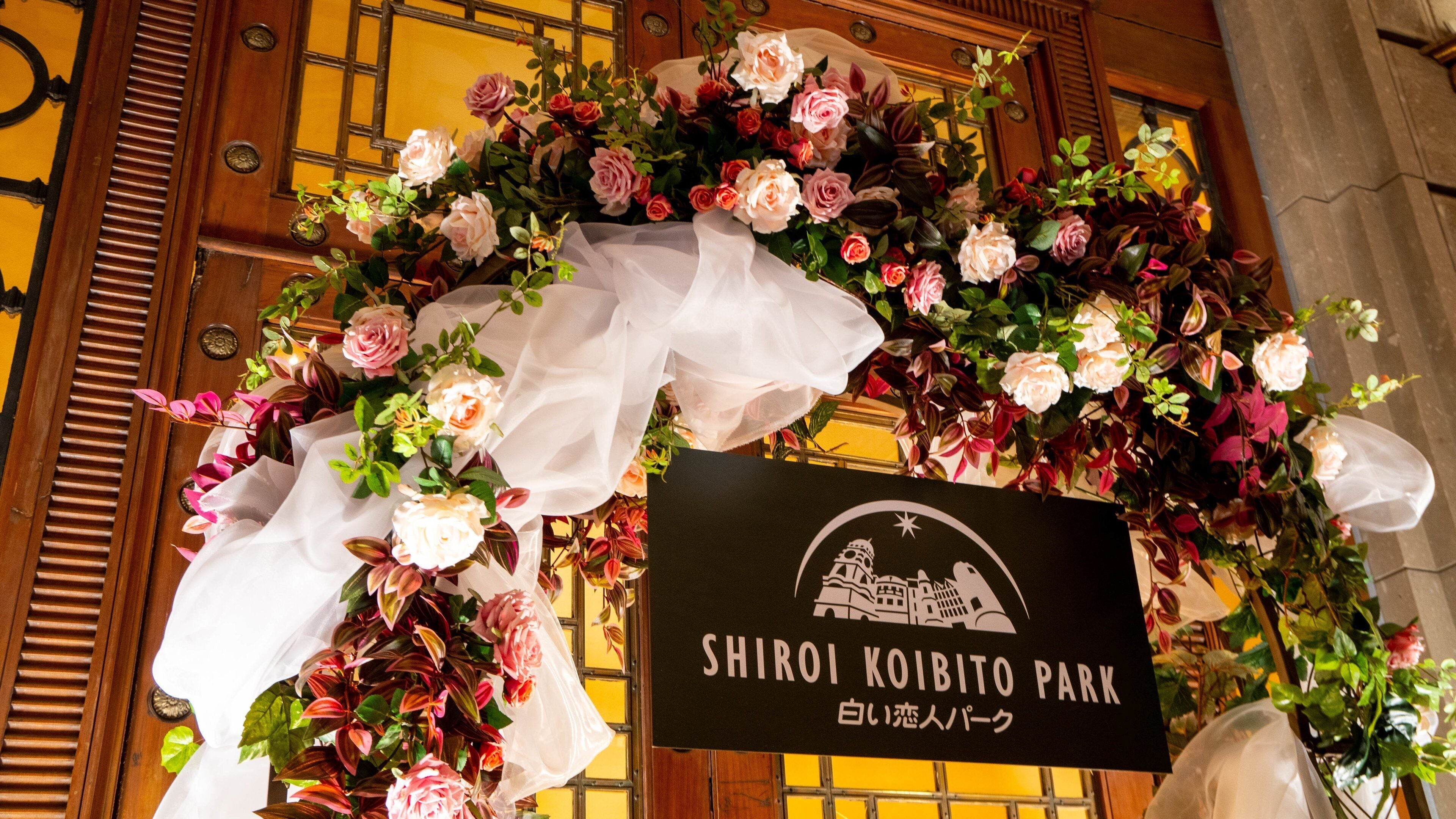 Placa indicativa para o Parque Shiroi Koibito, com um arranjo floral acima.