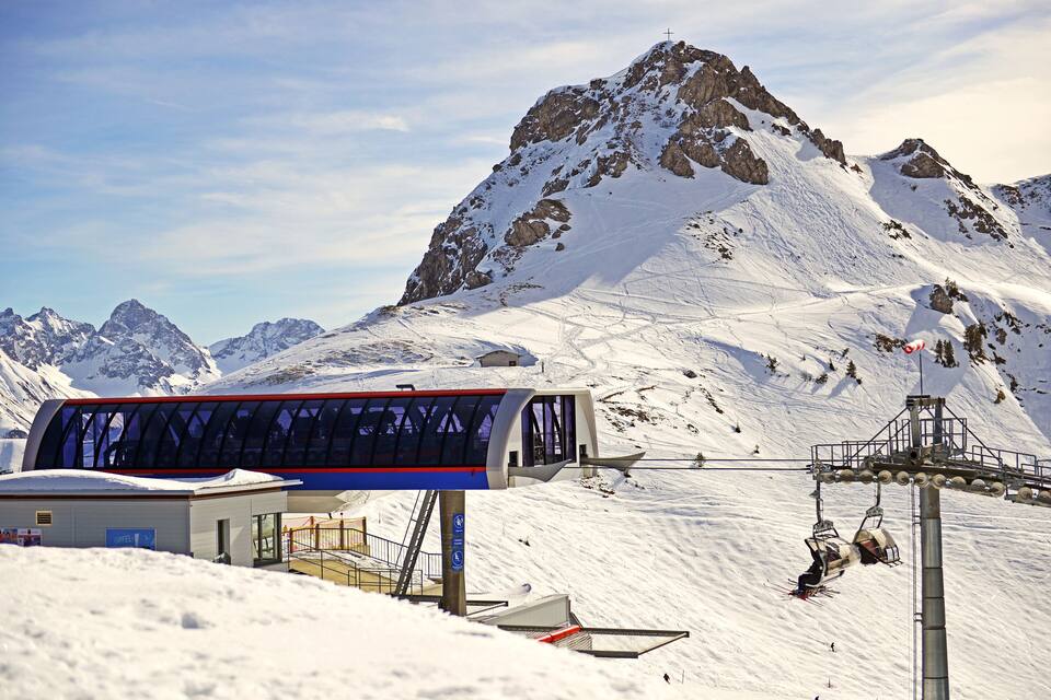 Montanha coberta de neve com um teleférico e uma estação de cabine.