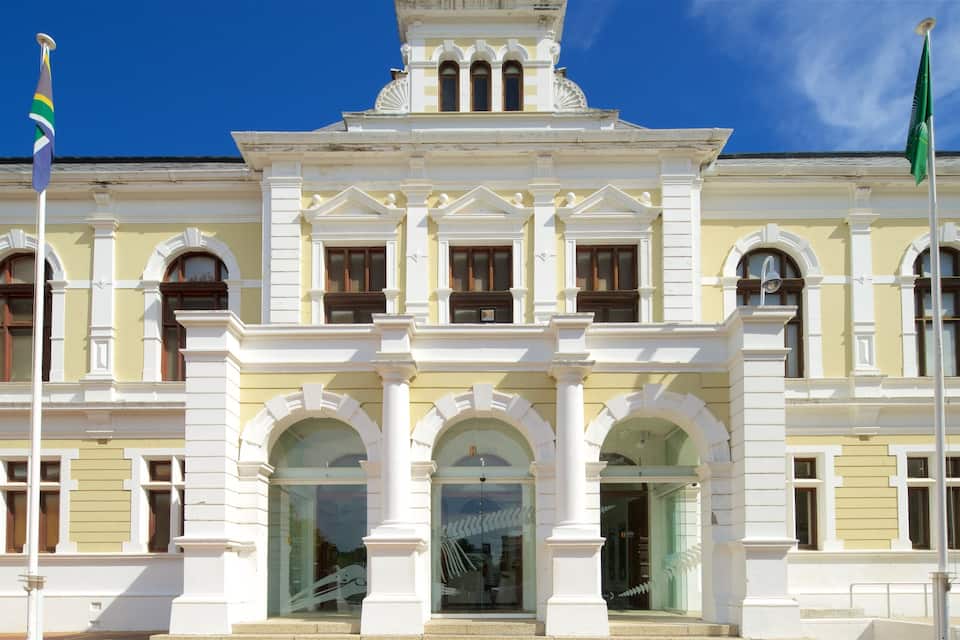 Um edifício histórico com arquitetura clássica, apresentando janelas em arco e uma entrada central.