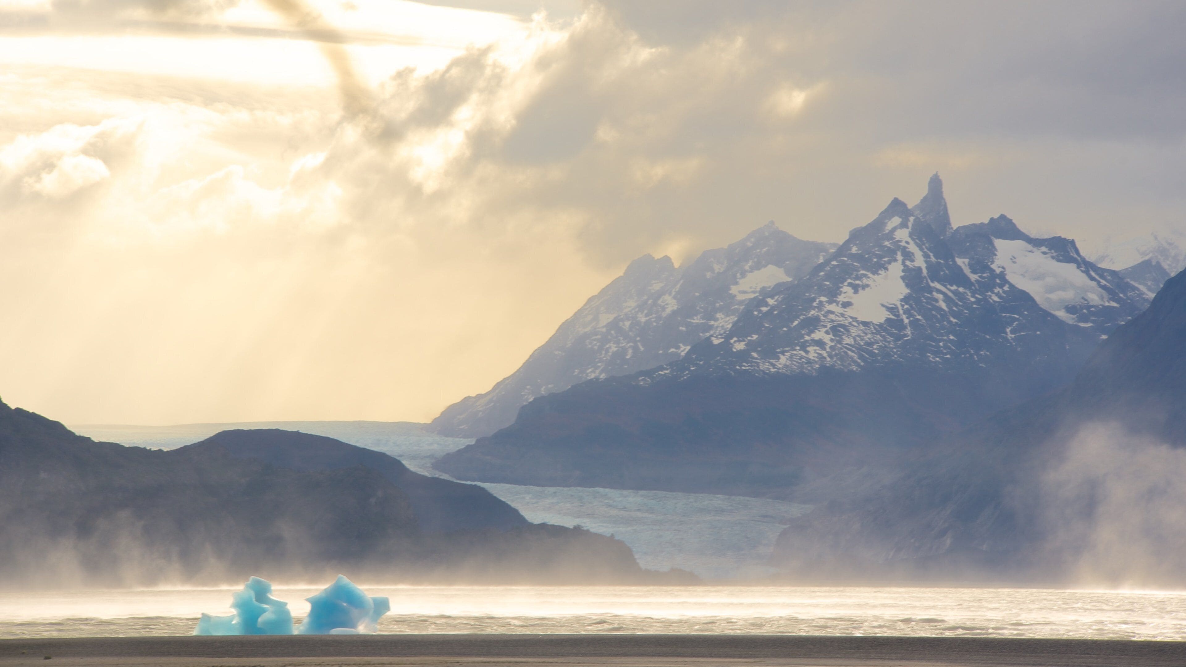 Um glaciar com icebergs em uma paisagem montanhosa.