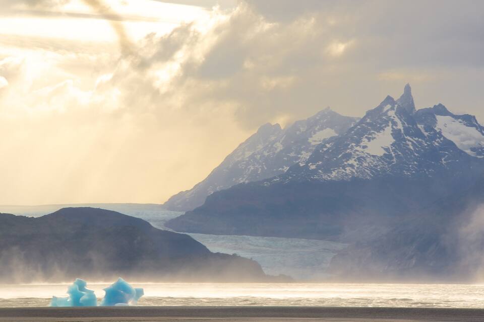 Um glaciar com icebergs em uma paisagem montanhosa.