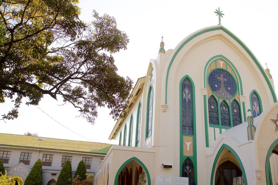 Uma igreja com arcos verdes e uma cruz no topo.