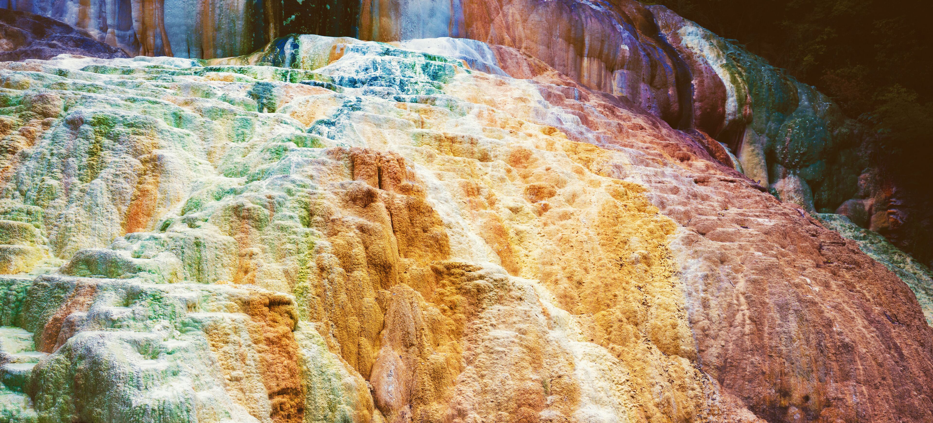 Paisagem em terraços com depósitos minerais multicoloridos.