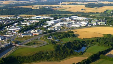 Vista aérea de uma cidade com edifícios industriais, estradas e campos ao redor.