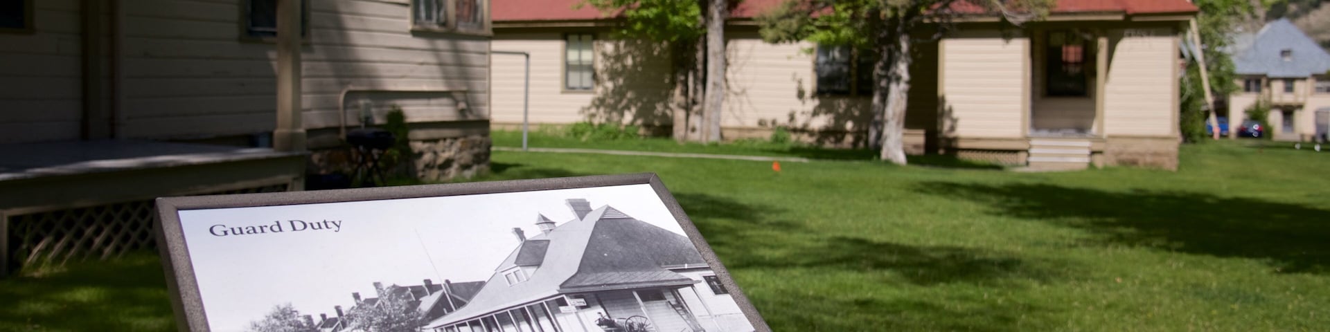 Placa histórica com o título 'Guard Duty', exibindo uma fotografia a preto e branco de uma casa e uma descrição da sua importância.