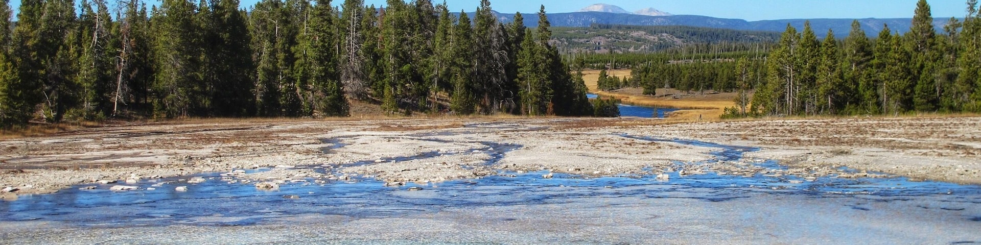 Opal Pool with a glimpse of Firehole River through the tree and Mount Holmes beyond in the distance #nationalpark #blue #nature