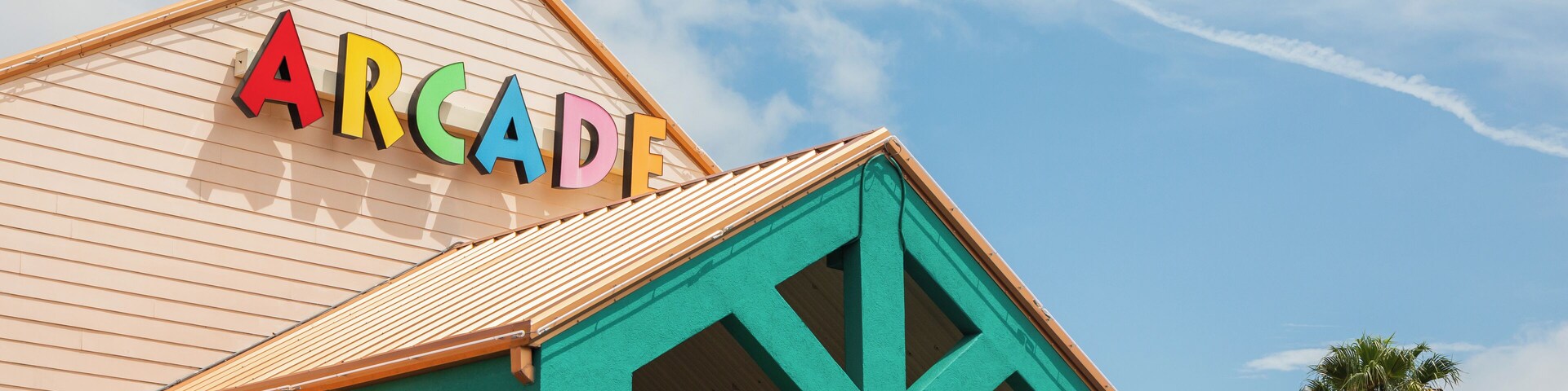 Um edifício com uma placa que diz 'Arcade' e 'Bem-vindos à Ilha da Aventura'.