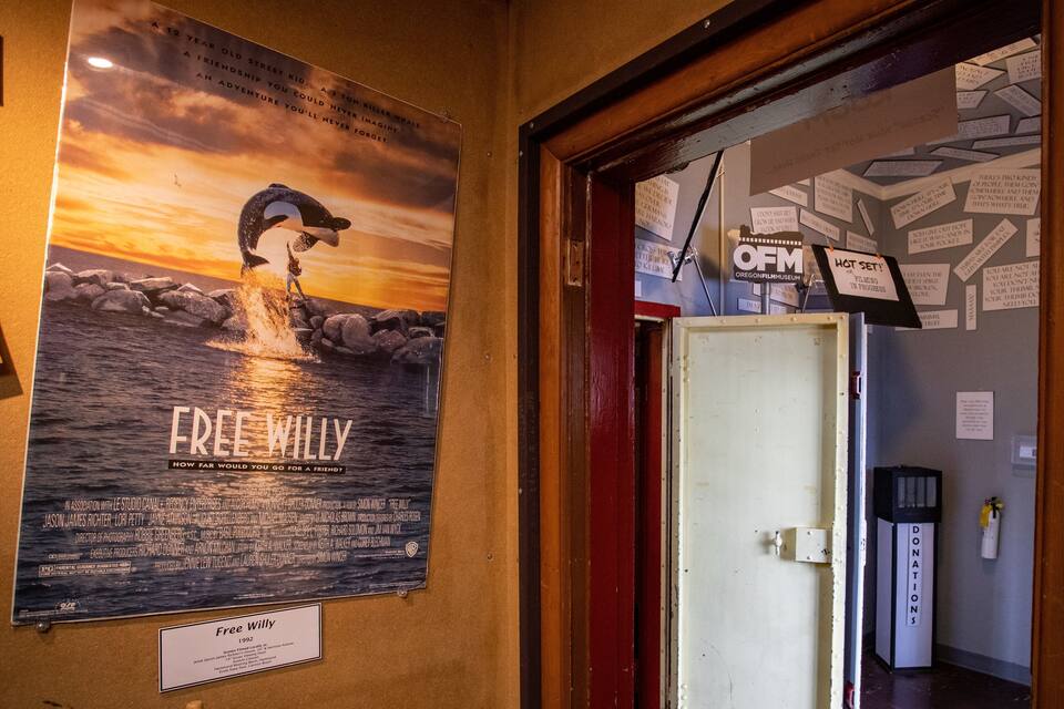 Cartaz do filme 'Free Willy' e uma porta com o letreiro 'DOAÇÕES'.