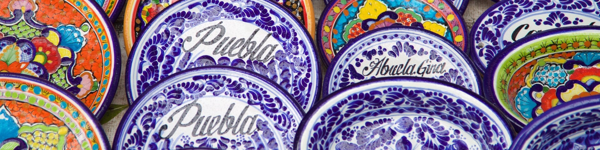 Uma coleção de pratos de cerâmica coloridos, com desenhos detalhados e texto.