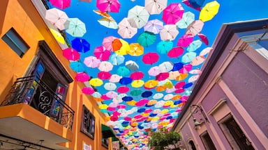 Uma rua com guarda-chuvas coloridos pendurados no teto.
