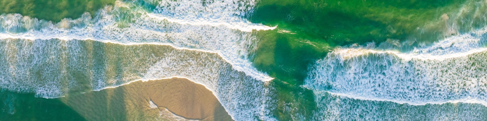 Uma praia com ondas quebrando na costa.