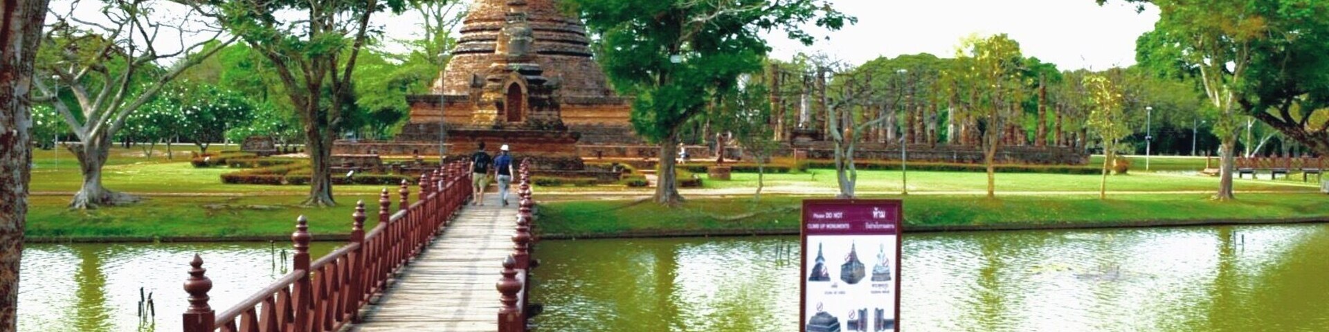 Um templo com um stupa, uma ponte sobre um lago e uma placa de 'Proibido Entrar'.