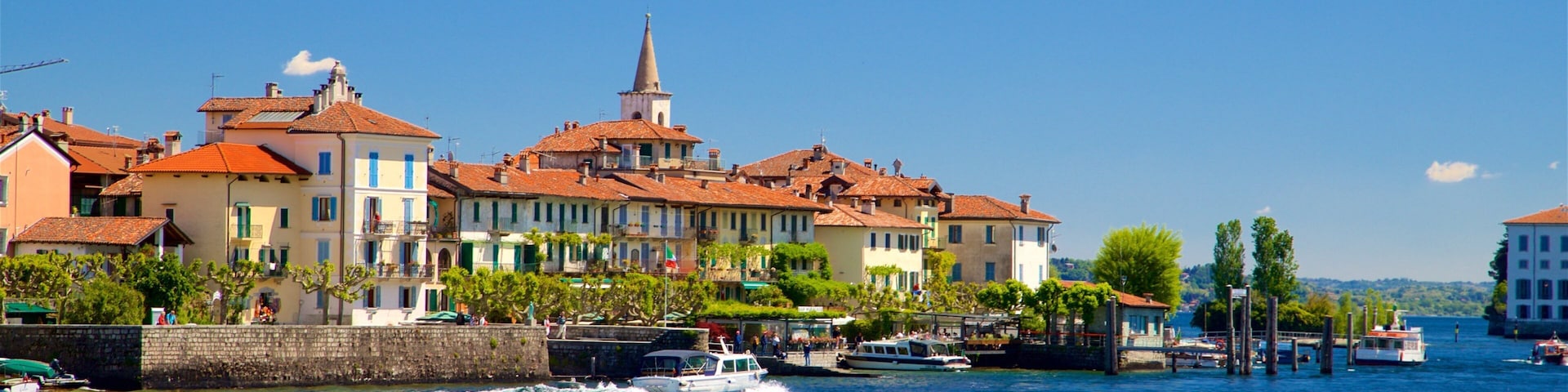 Uma vila costeira com edifícios históricos e um céu azul límpido.