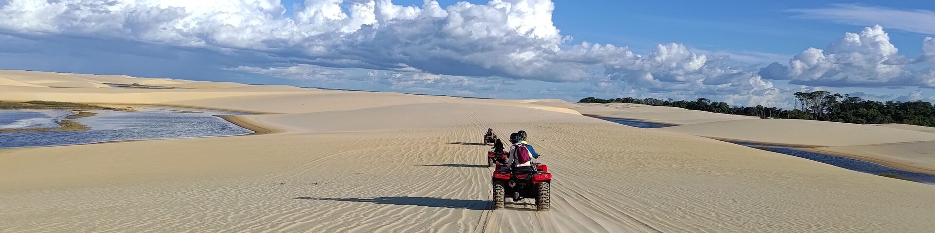 Vasta paisagem desértica com dunas de areia e um céu azul límpido.