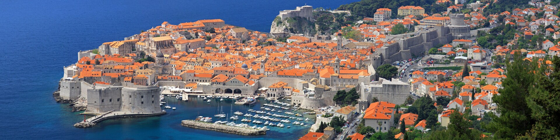 Uma cidade costeira com arquitetura histórica e um porto cheio de barcos.
