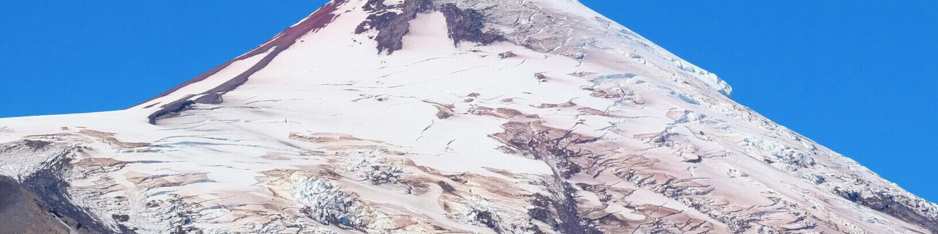 Montanha coberta de neve com céu azul límpido.