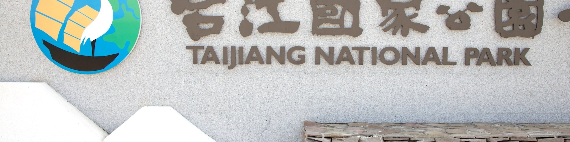 Placa indicativa do Parque Nacional Taijiang, com logotipo e caracteres chineses.
