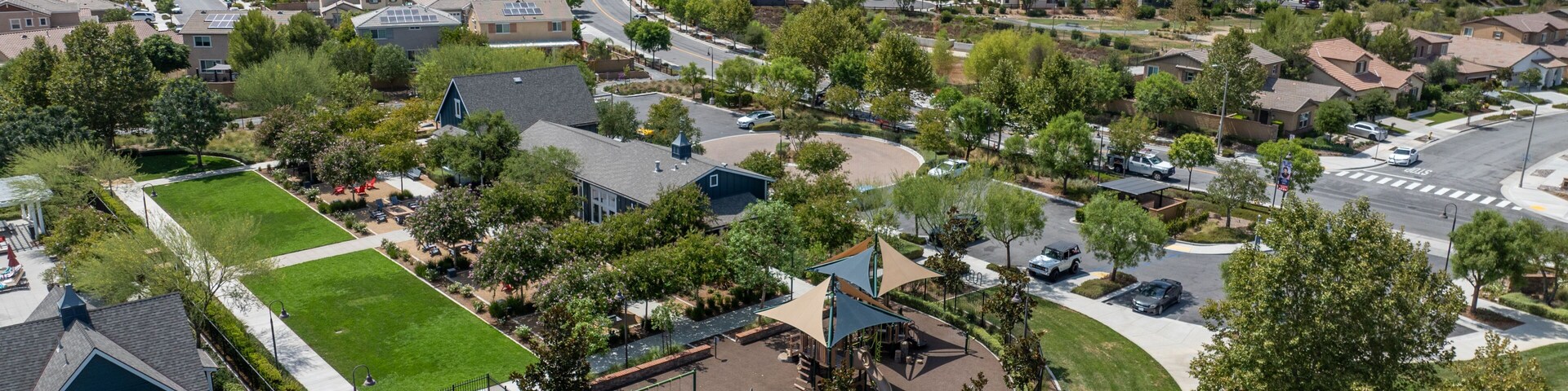 Um bairro residencial com casas, áreas verdes e um parque central.