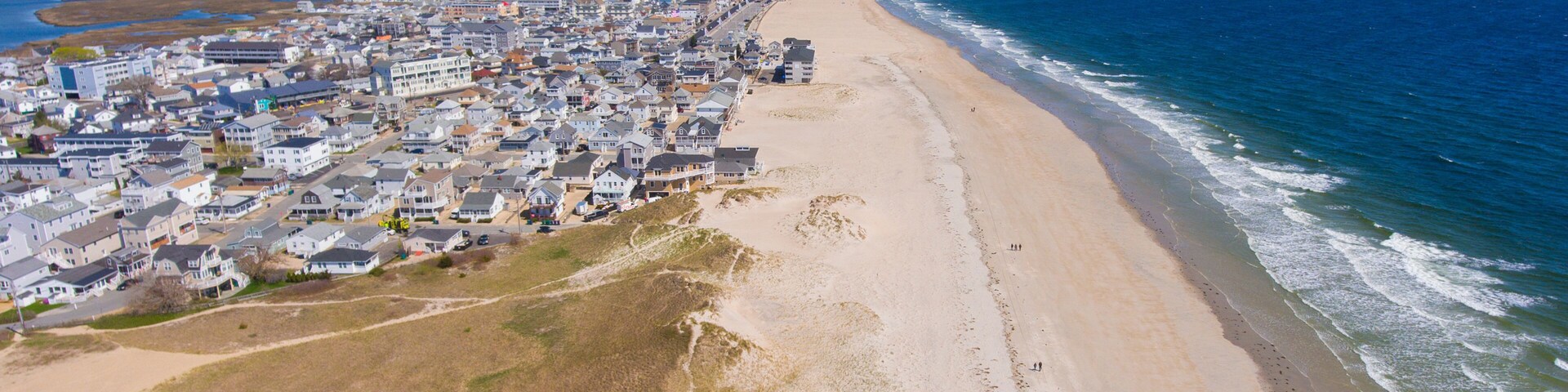 Uma cidade costeira com praia, oceano e área residencial.