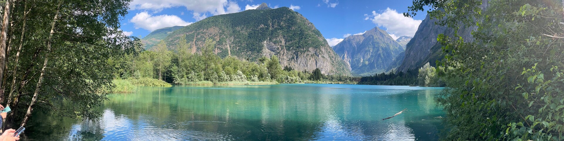 Um lago tranquilo rodeado por vegetação exuberante e montanhas.