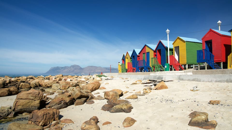 Cidade do Cabo que inclui uma cidade litorânea, uma praia de areia e litoral acidentado