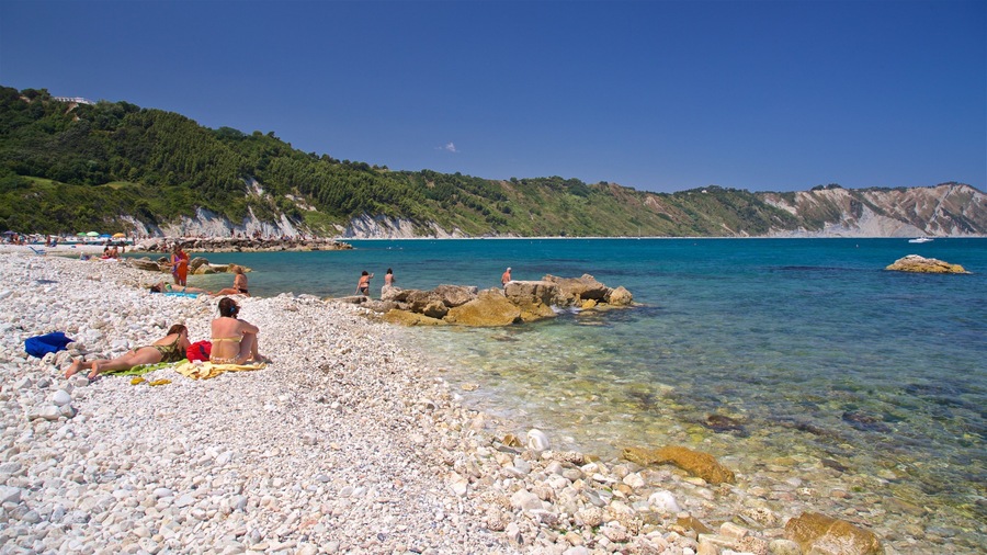 Portonovo mostrando uma praia de pedras e paisagens litorâneas assim como um pequeno grupo de pessoas