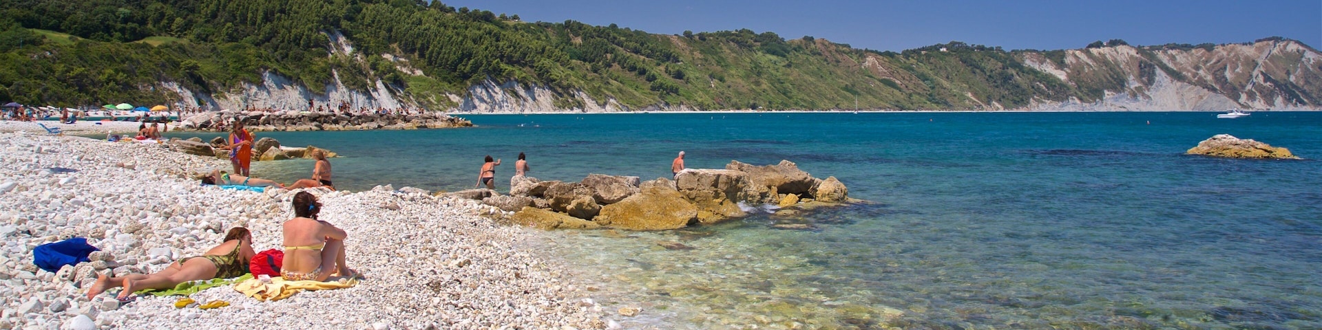 Portonovo mostrando uma praia de pedras e paisagens litorâneas assim como um pequeno grupo de pessoas