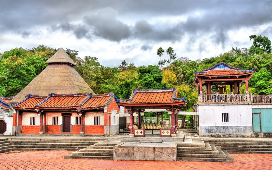 Um templo tradicional com telhado cônico, um pavilhão com telhado ladrilhado e uma escadaria que leva ao templo.
