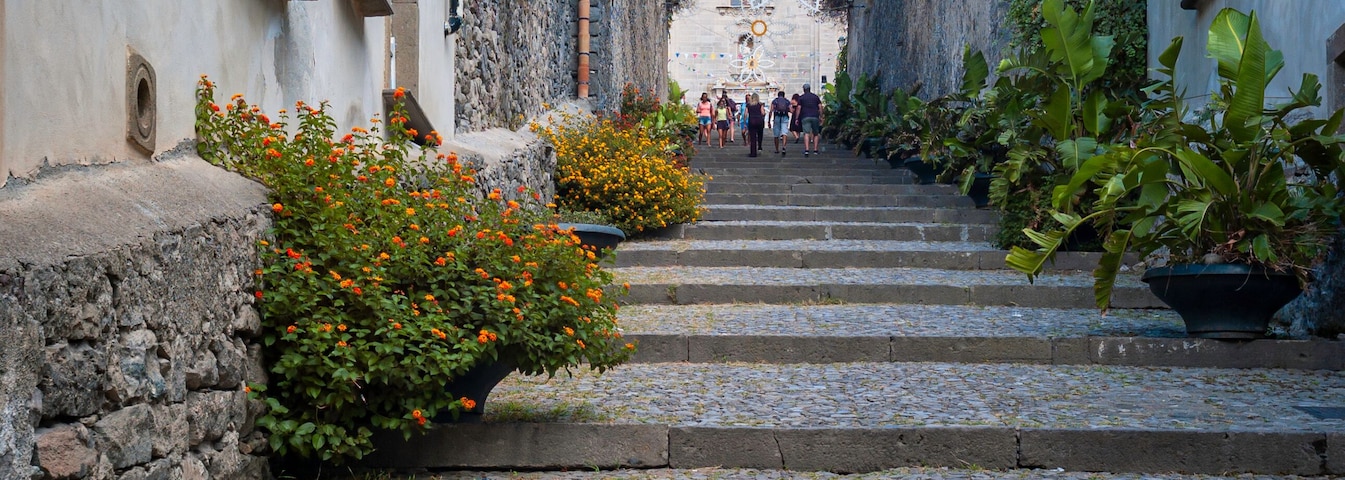 Uma rua de paralelepípedos que leva a uma igreja histórica com um campanário.