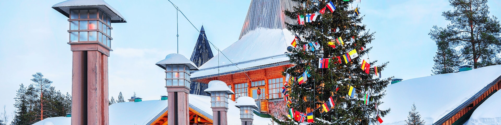 Paisagem coberta de neve com um pinheiro decorado para o Natal, um boneco de neve e uma cabana de madeira.