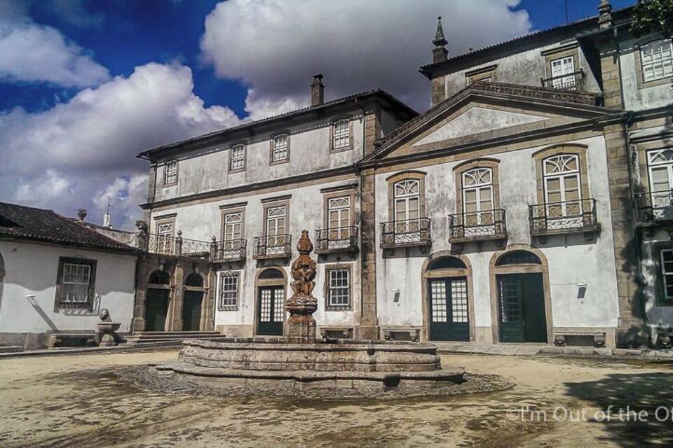 Um edifício histórico com uma fonte no pátio.