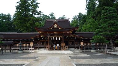 Um templo japonês tradicional com um pátio de telhas e bancos de madeira.