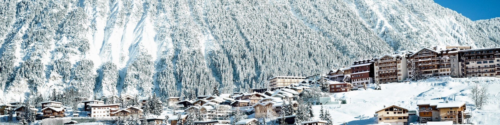 Estação de esqui de Courchevel que inclui uma cidade pequena ou vila, neve e montanhas