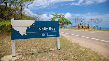Placa de Nelly Bay com paisagem costeira ao fundo.