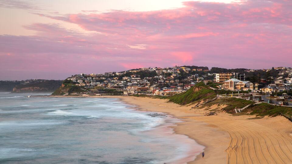 Bar Beach featuring a sandy beach, a coastal town and a sunset