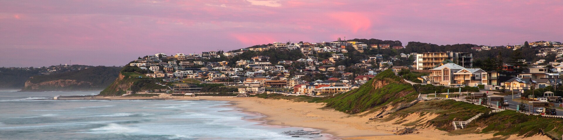 Bar Beach featuring a sandy beach, a coastal town and a sunset