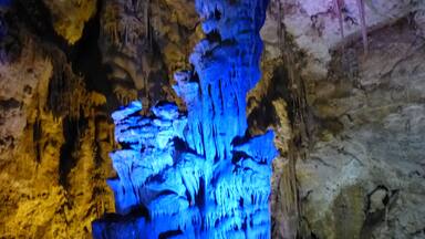 Caverna com estalactites iluminadas em azul.