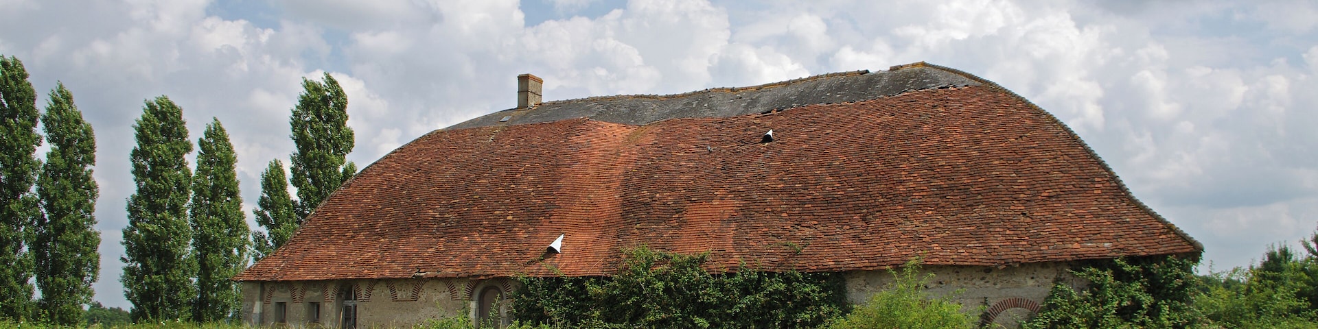 Mesland (Loir-et-Cher) Grange de la Perdrière. 47° 30' 33.6456" N 1° 7' 22.2384" E
 Cette grange semble dater du dernier quart du 18e siècle et du 1er quart du 19e siècle. Elle dépend du château de Monteaux et appartient à une société privée. Sa toiture particulière, semble sans équivalent dans le Loir-et-Cher. Les caractéristiques techniques de sa charpente permettent de dater la construction de la fin du 18e siècle. Les fermes sont constituées de 3 cours de planches formant un arc ogival rapprochées par des clous en fer forgé. Les fermes, sont les éléments de charpente qui supportent le poids de la toiture (triangulaires dans le cas de la charpente traditionnelle, mais ce n'est pas le cas ici). Le type de charpente est dit à la Philibert de l'Orme. Ce religieux du 16e siècle est surtout connu pour ses travaux d'architecture. En particulier, dans le livre X de son "Premier tome de l'architecture", Philibert de l'Orme décrit un nouveau type de charpente pouvant utiliser du bois court pour des toitures à grand développement. Ce type de charpente est cher en main d'oeuvre, économe en bois et généreux en espace. Une toiture à la Philibert de l'Orme ressemble à une carène de navire renversée. This barn appears to date from the last quarter of the 18th century and the first quarter of the 19th century. The type of timber work is said to Philibert de l'Orme. It is a timber work frame-shaped hull ship