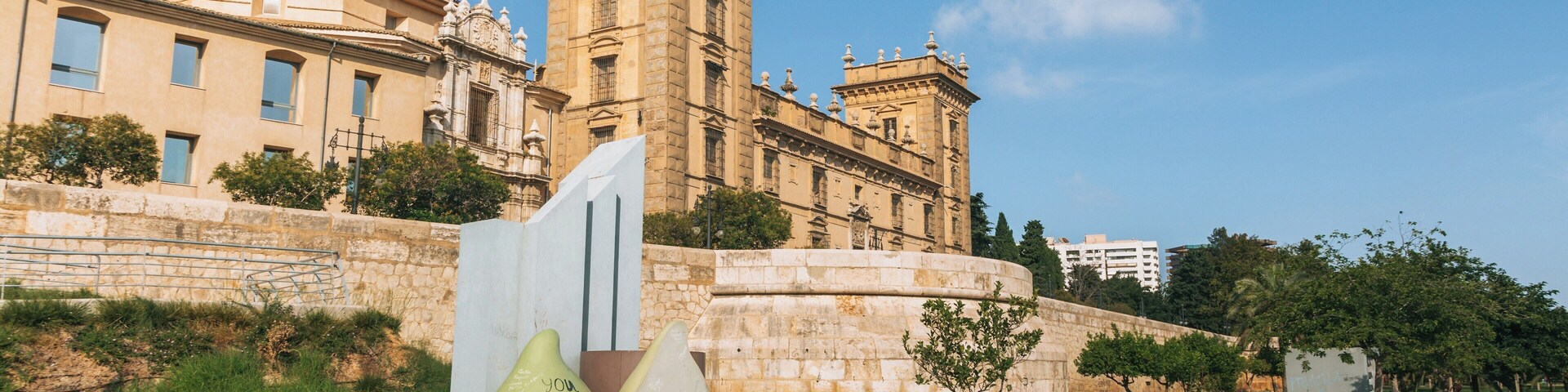 Um edifício histórico com uma cúpula e uma grande escultura de uma pera verde e uma pera branca com a inscrição 'You lift me up'.