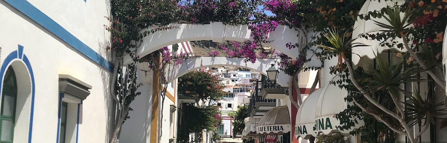 Small fishing village 15 Euro taxi ride or boat ride from Puerto Rico - lovely place for a harbour lunch, quaint old town, nice little beach with plenty of water sports and a huge market held every Friday. Worthy of a visit :)