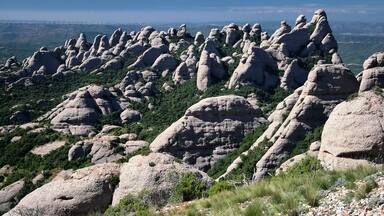 Paisagem de formações rochosas imponentes e vegetação rala.