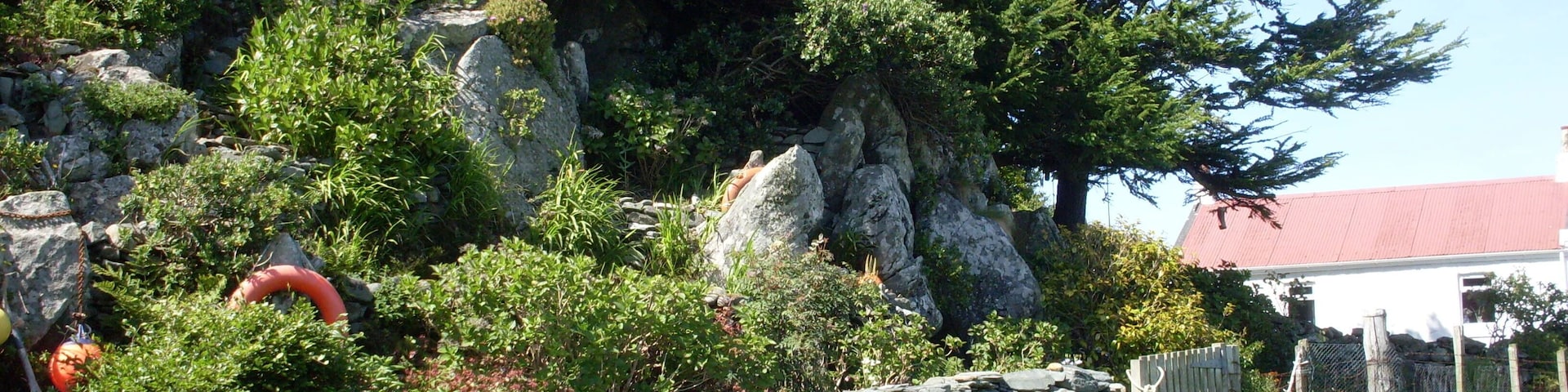 Garden at Cuddieport A charming "rock" garden wrested from the hill behind the cottage, utilising natural features and tons of stone.